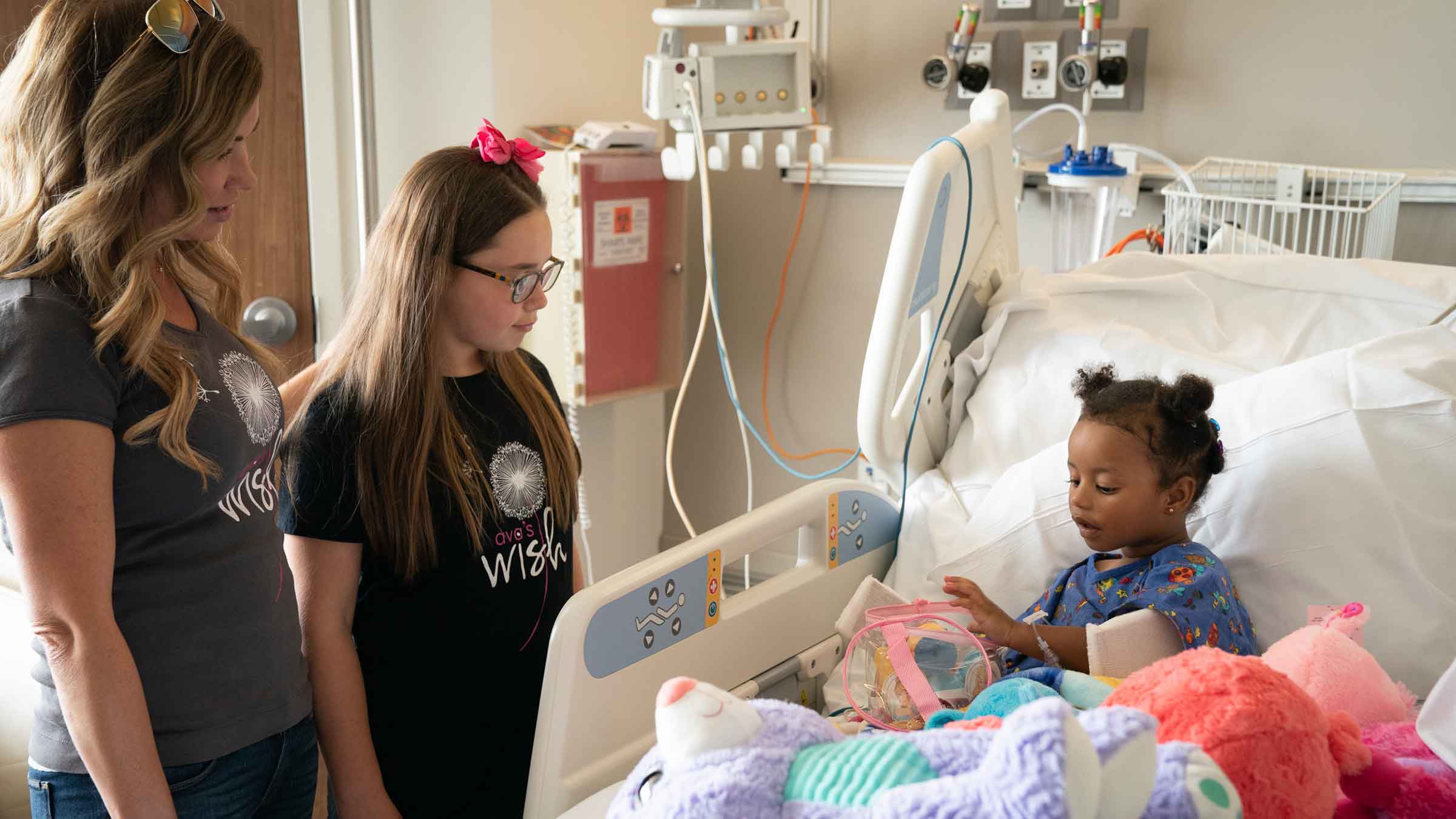 Two girls visit another girl in the hospital