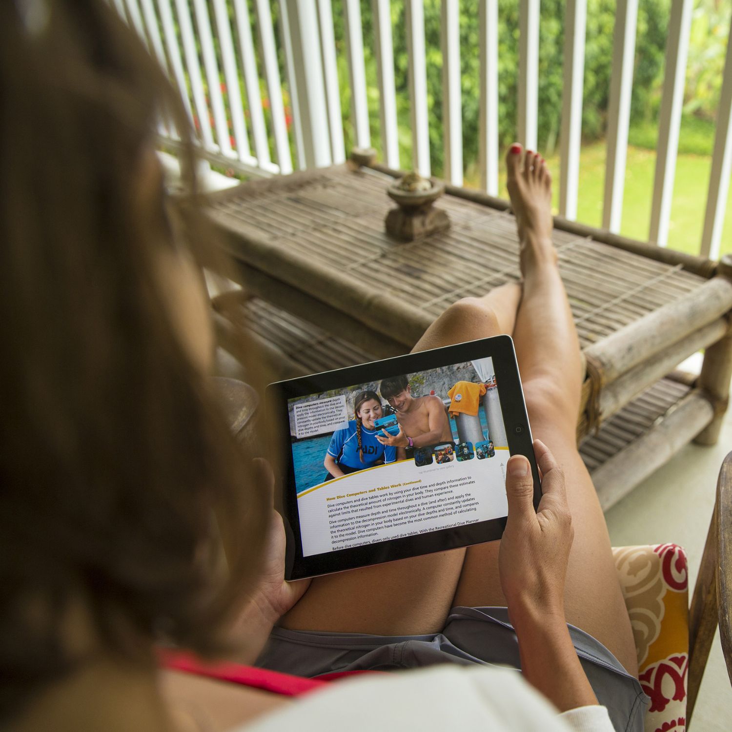 Woman sitting with a tablet on her lap looking at PADI eLearning