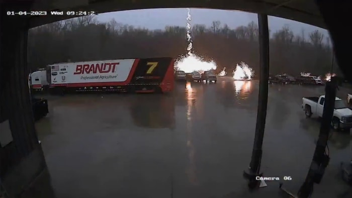 Video shows sparks fly as lightning strikes truck, runs along a fence