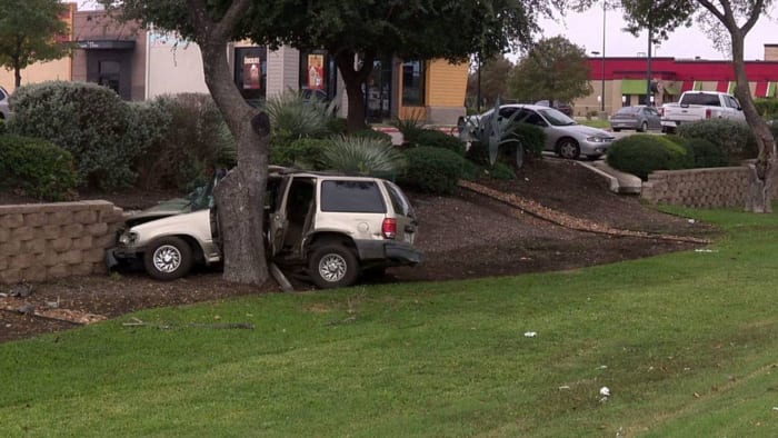 SUV runs off road, wraps around tree