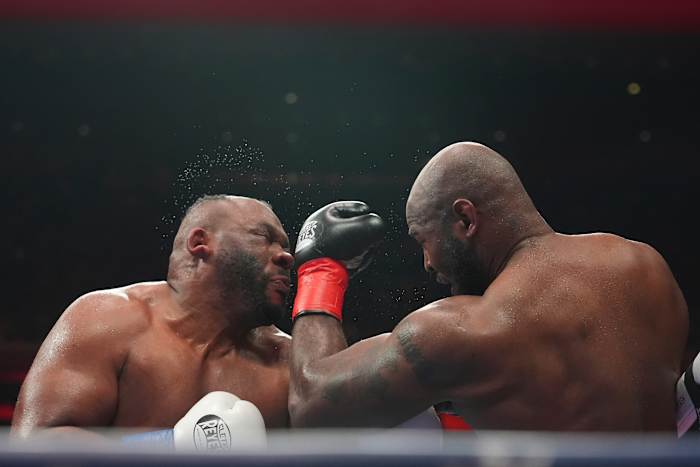 Boxer Jarrell Miller has his hairpiece knocked upward by a punch, then ...