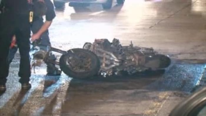Motorcycle catches fire, after rider crashes into back of car