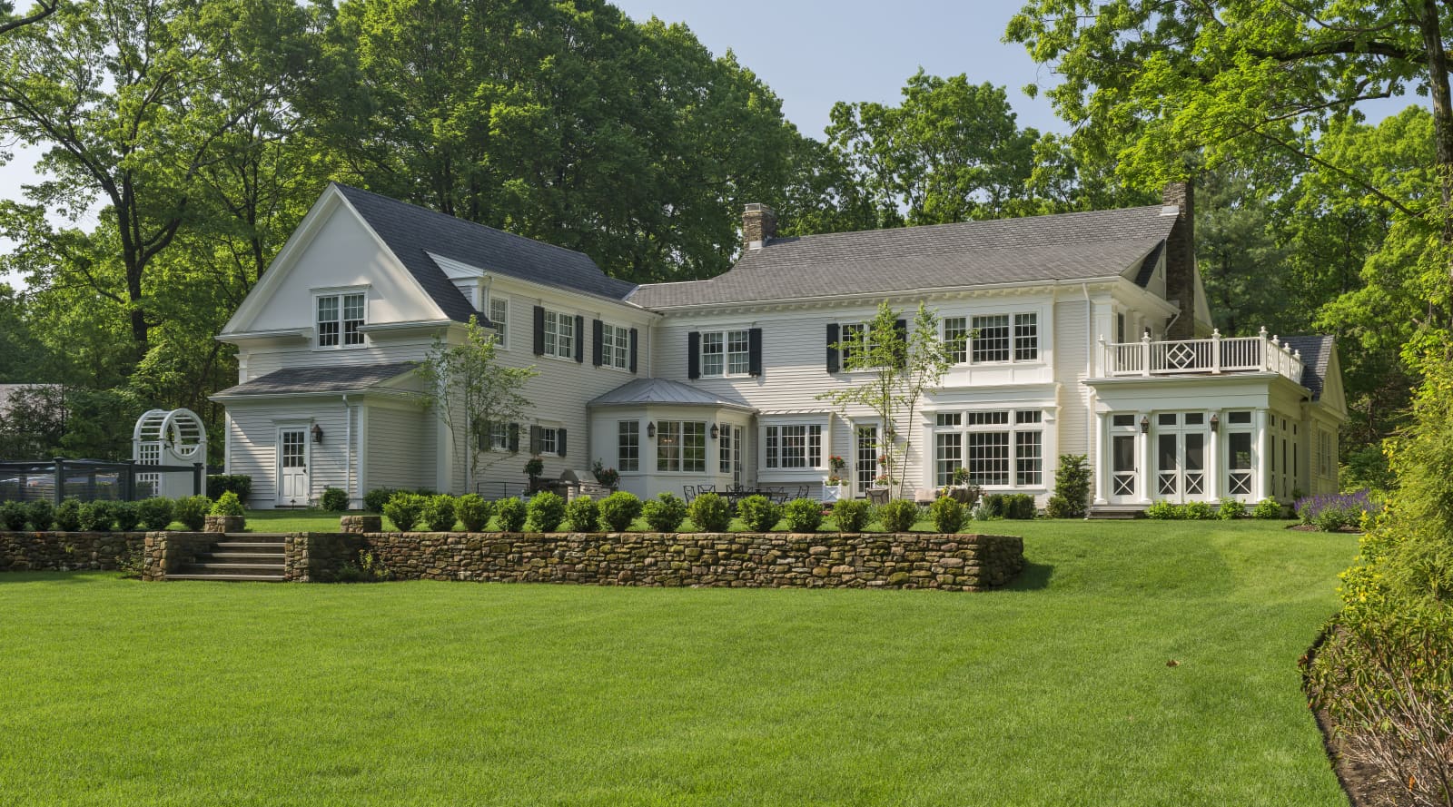 New England Colonial house with fieldstone siding,… | Trends