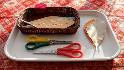 Snipping around paper feathers | Via Montessori